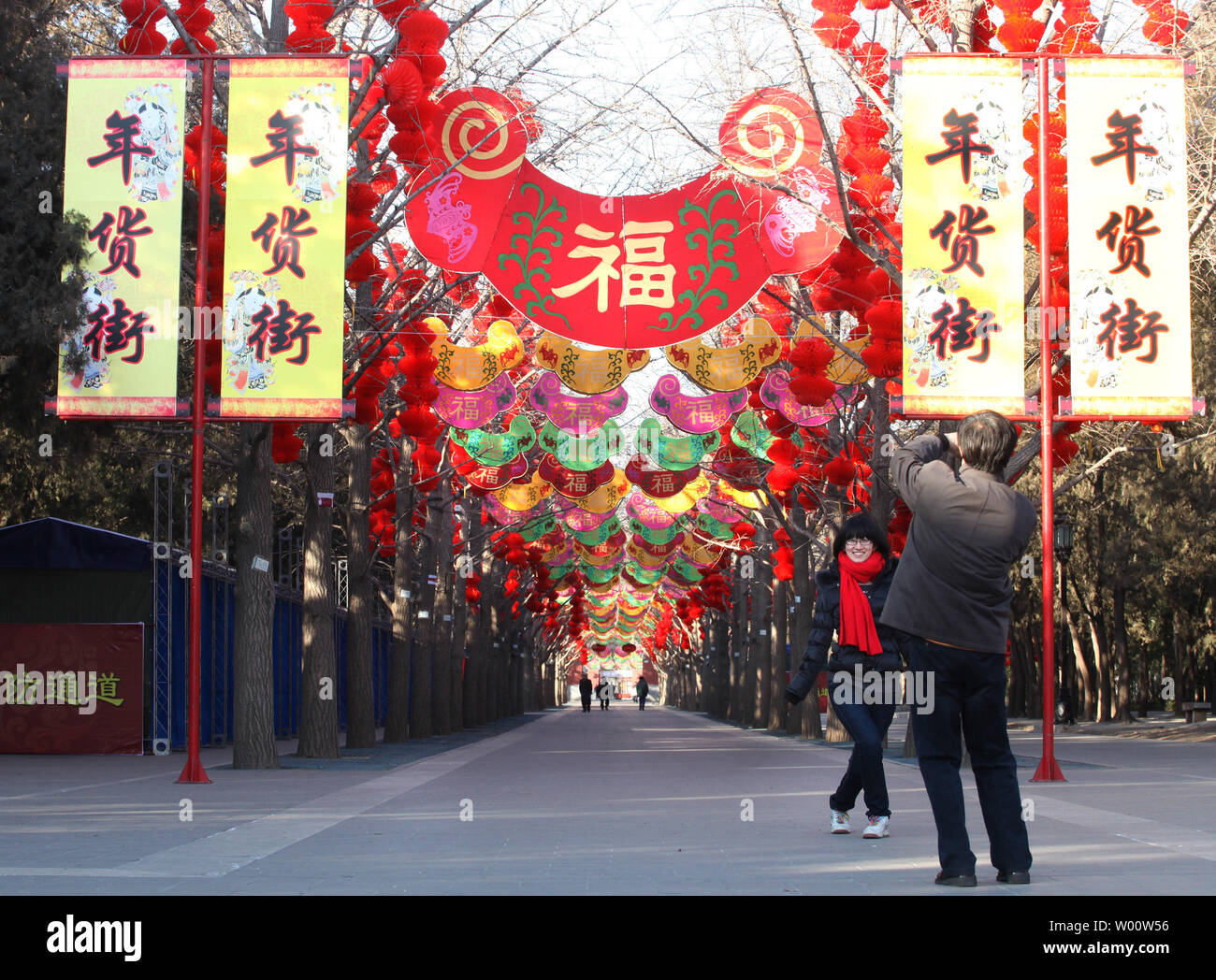 Chinese stroll under traditional red lanterns and 'good luck' banners ...