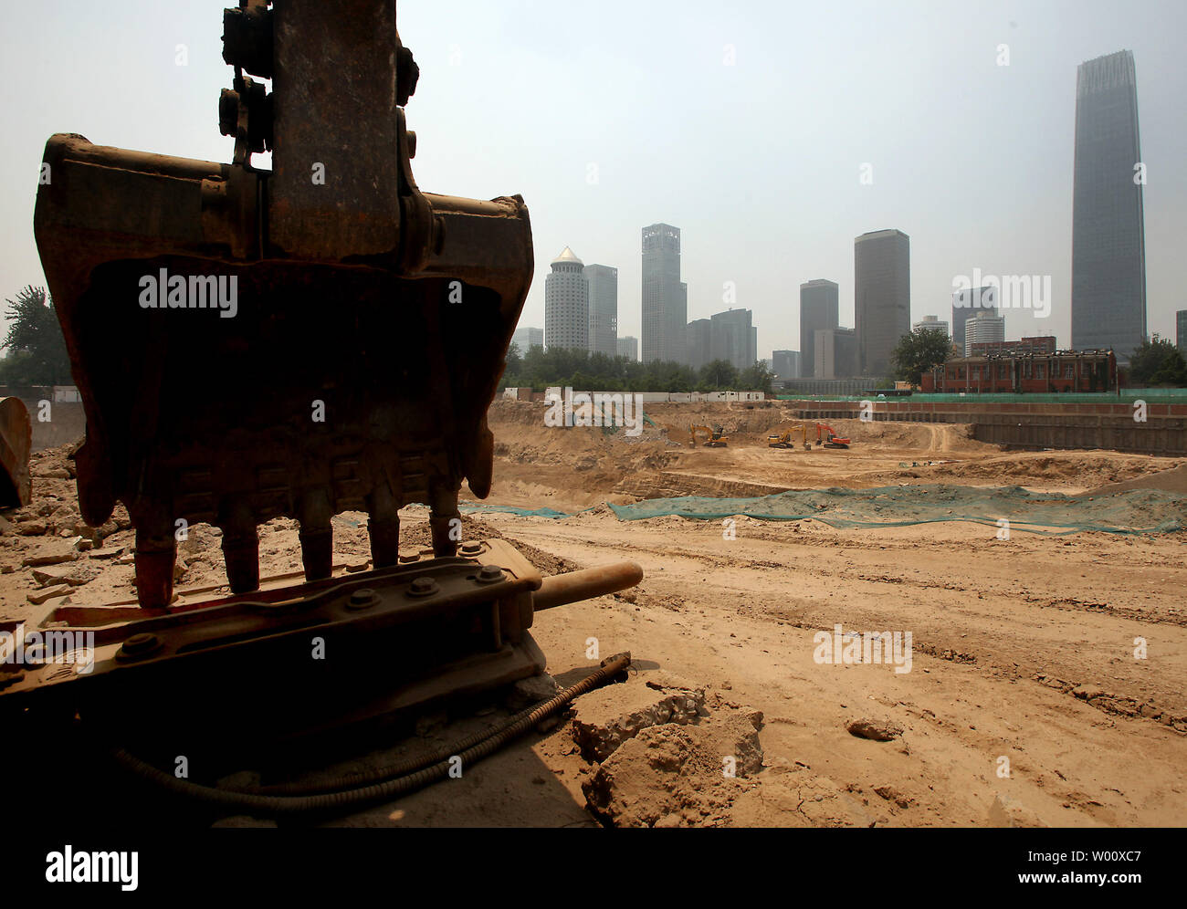 Cranes dig a massive pit on a construction site for a new ...