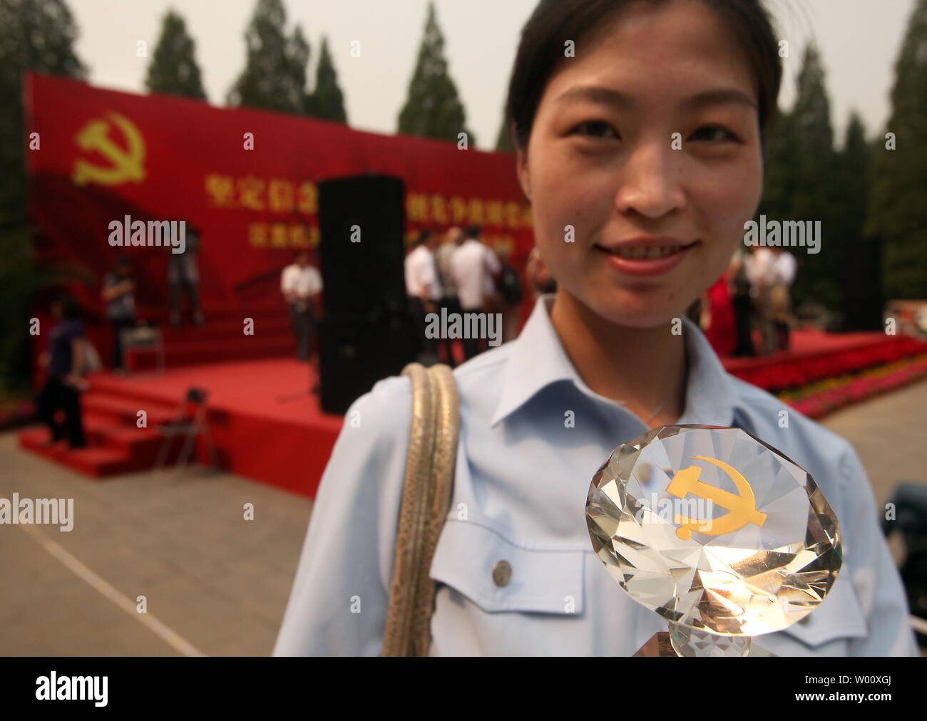 A Chinese woman shows her trophy for being an outstanding 'young ...