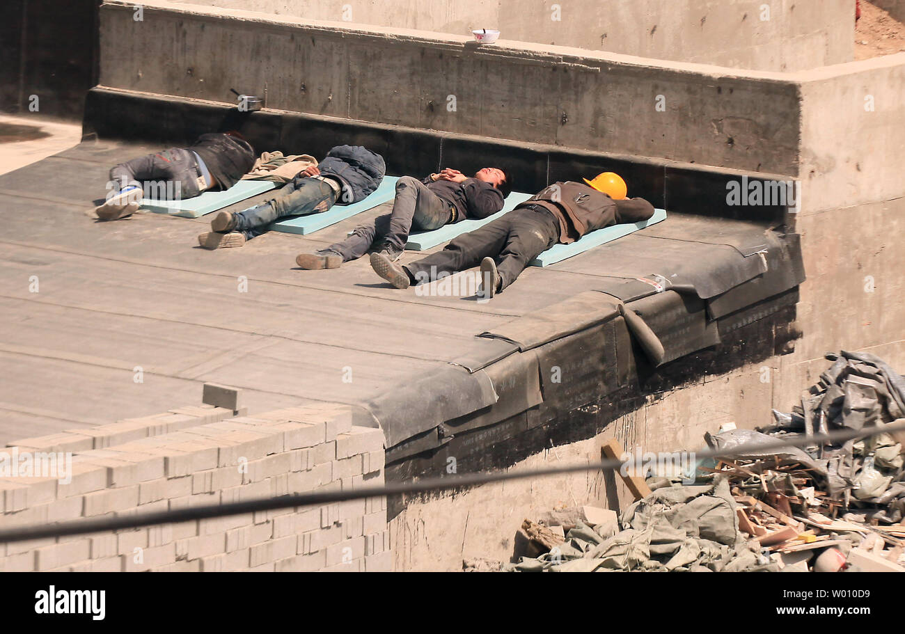 Migrant Chinese construction workers sleep on a building site in ...