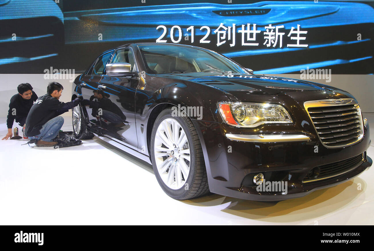 Chinese workers clean a new Chrysler 300C on display at the world's ...