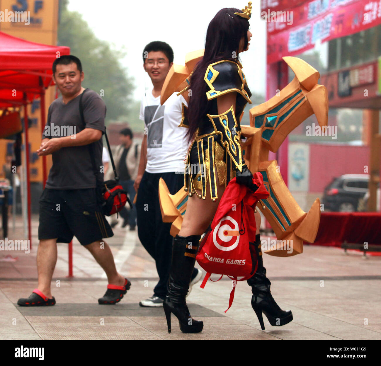 A Chinese model dressed as a mythical warrior walks with her 'weapon ...