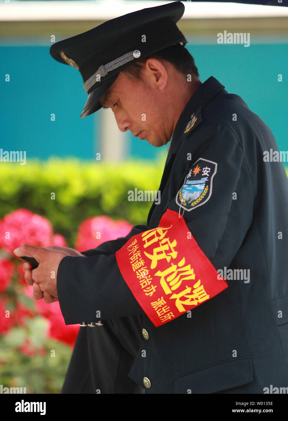 A Chinese security guard uses his mobile phone outside a shopping ...