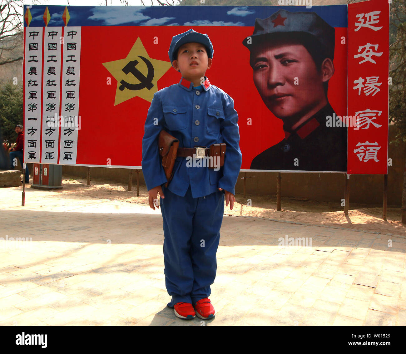 A Chinese boy dressed in a communist uniform poses for a photo, in ...