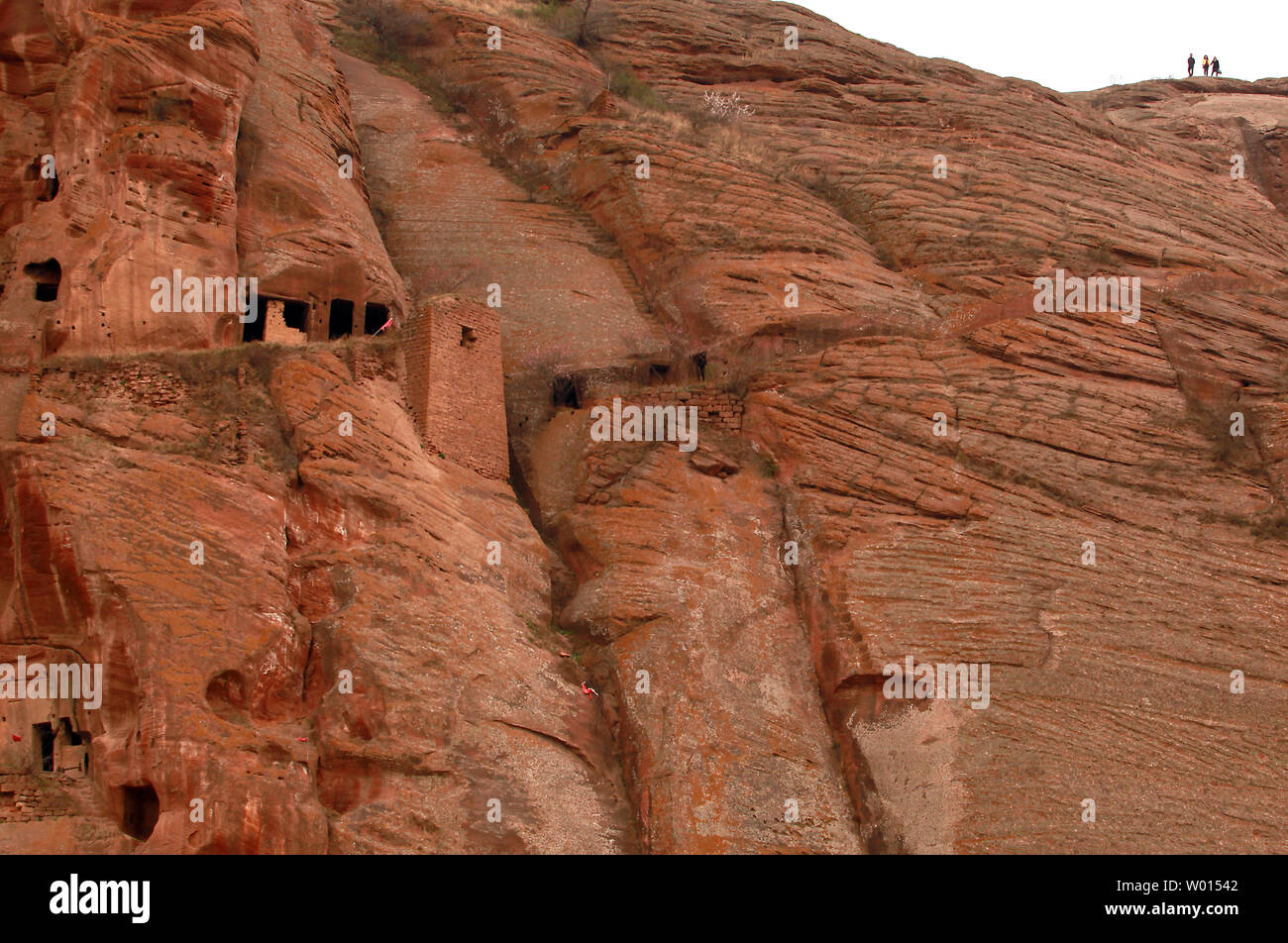 Chinese tourists explore an archeological site where prehistoric cave ...