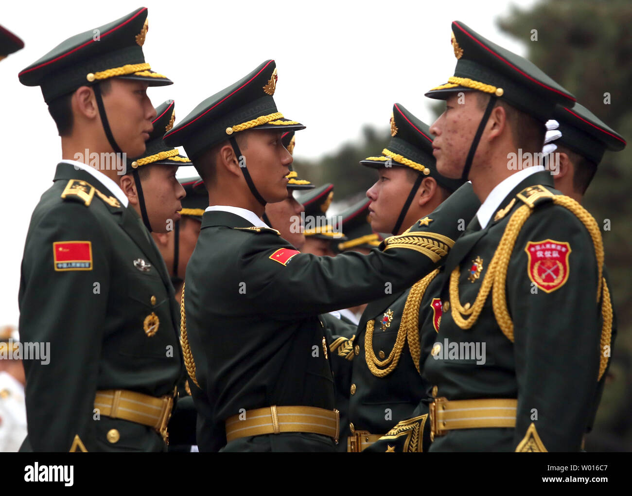 Chinese soldiers prepare to perform honor guard duties at a welcoming ...