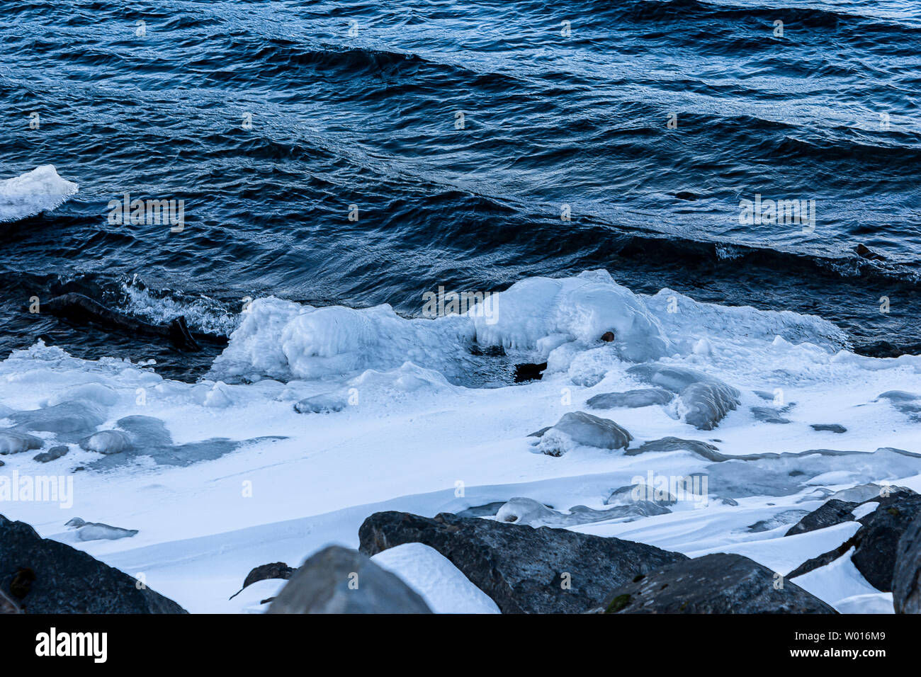 Beautiful winter landscape. The waves of the Harrison lake freeze ...