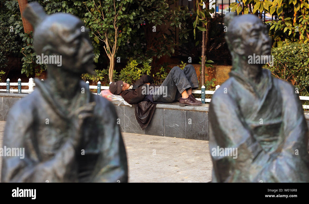 A homeless Chinese man sleeps in a park in Beijing on November 30, 2014 ...
