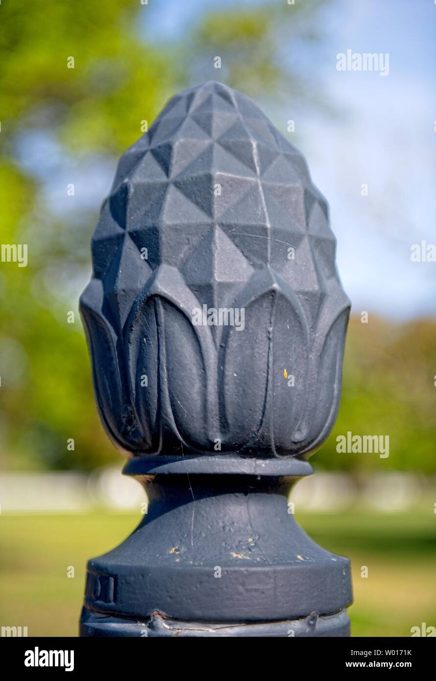 An up-close view of a finial isolated with trees out of focus in the ...