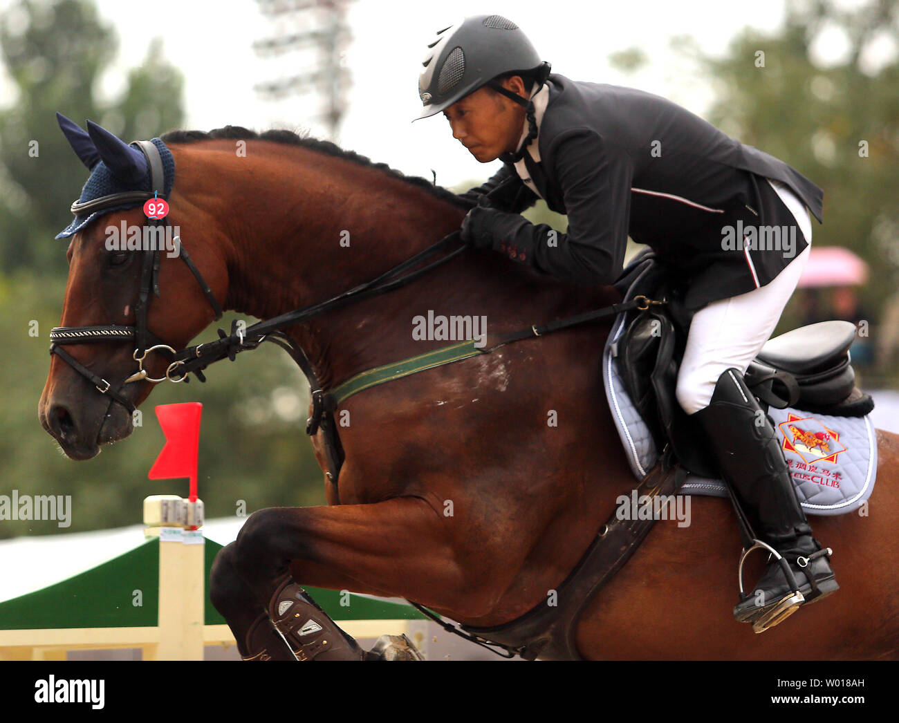 A Chinese jockey competes in the First China Show Jumping Open at the ...