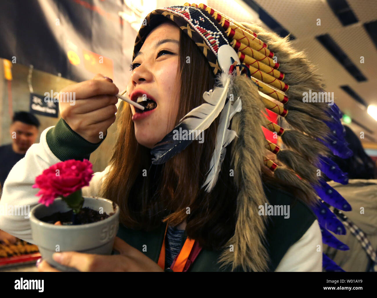A Chinese woman, wearing a native American headdress, enjoys Western ...