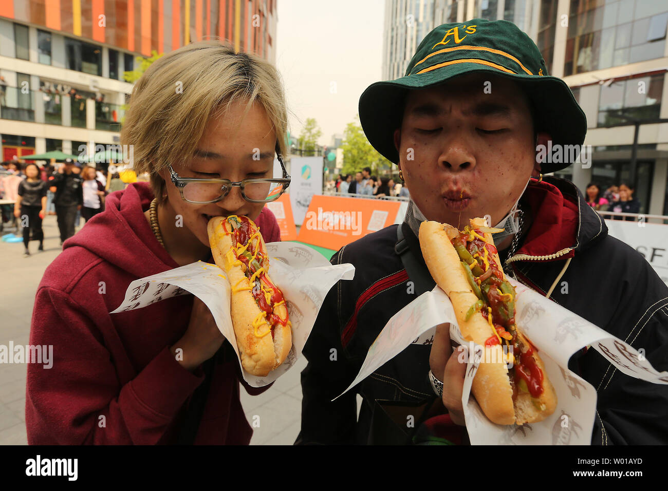 A Chinese couple enjoys Western-style sausages with onions and peppers ...