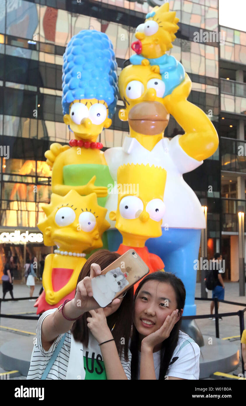 Chinese girls take a selfie in front of 'The Simpsons' display at an ...