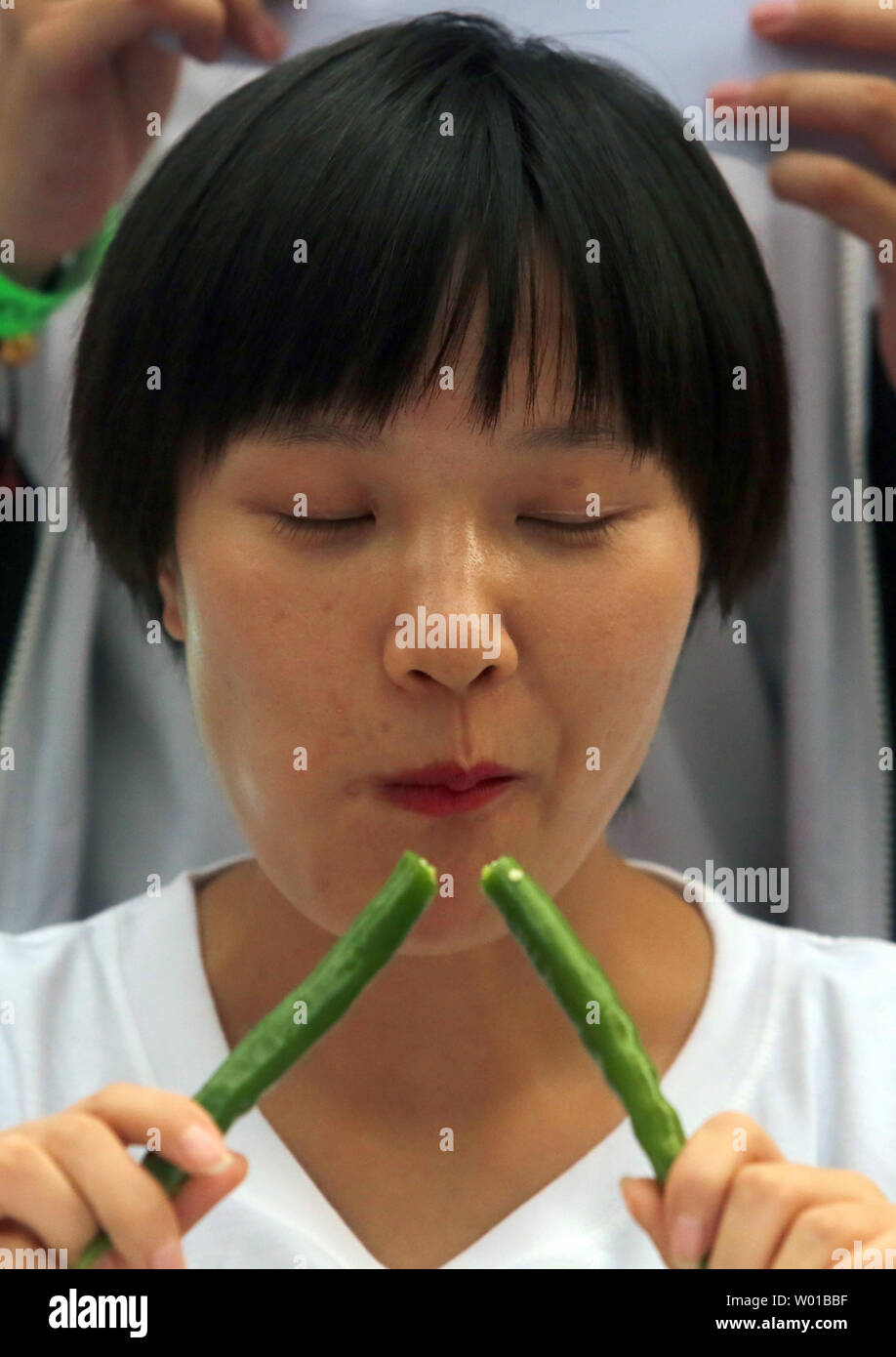 A Chinese woman competes in a chili eating contest at a food fair in ...
