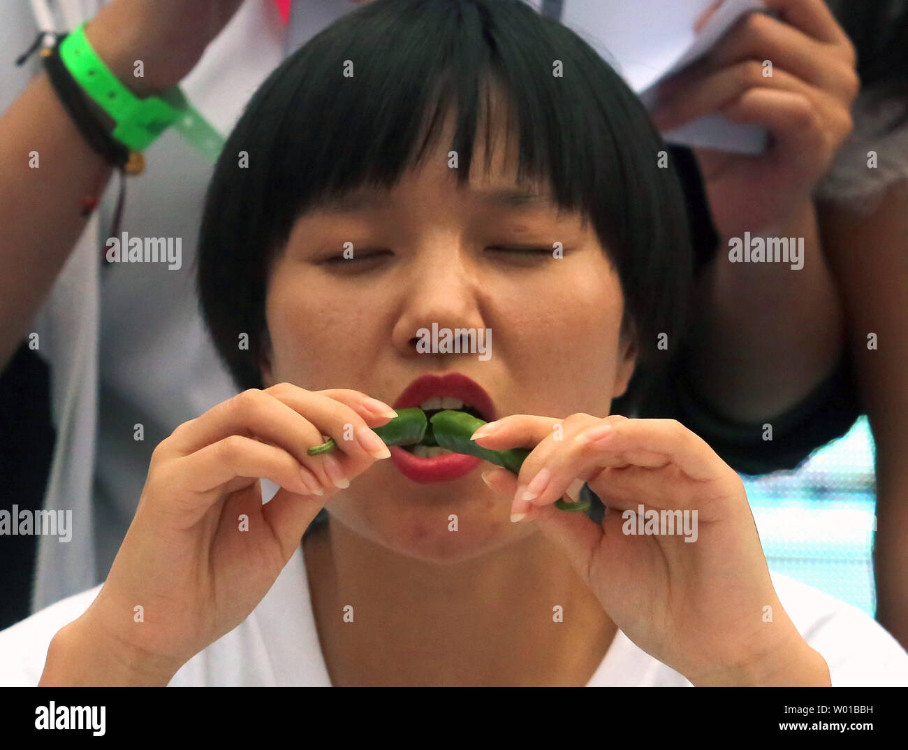 A Chinese woman competes in a chili eating contest at a food fair in ...