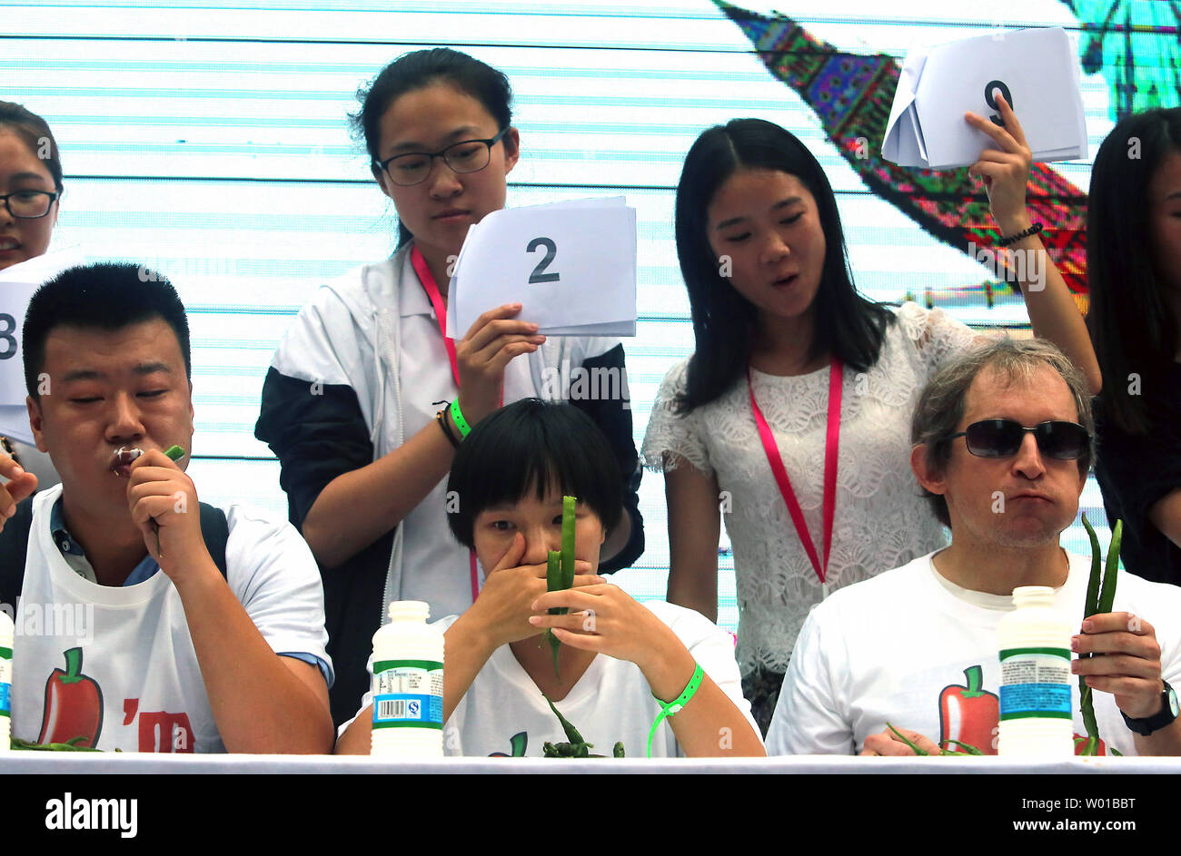 Chinese and foreigners compete in a chili eating contest at a food fair ...