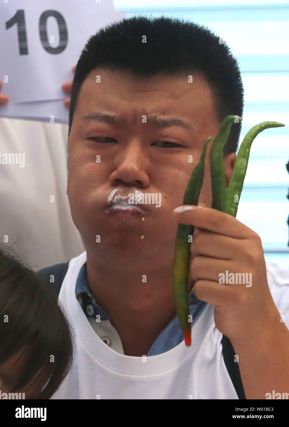 A Chinese man competes in a chili eating contest at a food fair in ...
