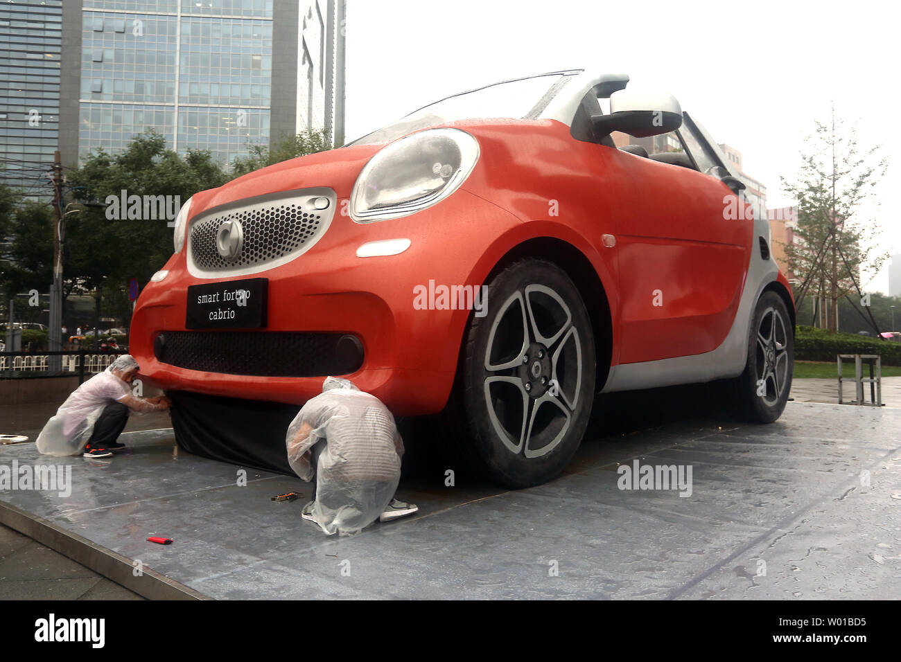 Chinese workers assemble a large MINI automobile display outside a ...