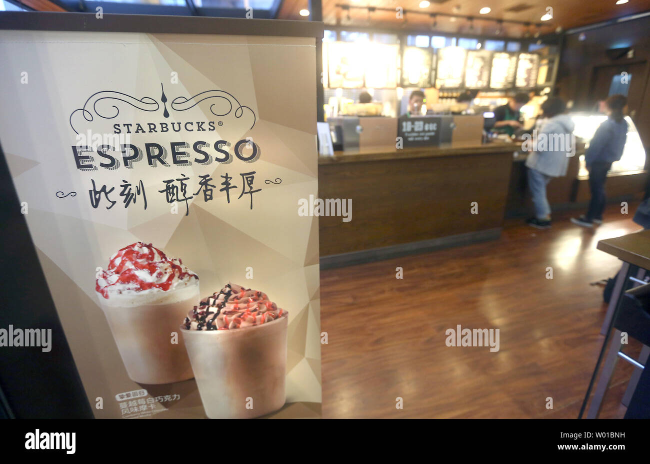 Chinese drink coffee at a Starbucks in central Beijing on October 24 ...