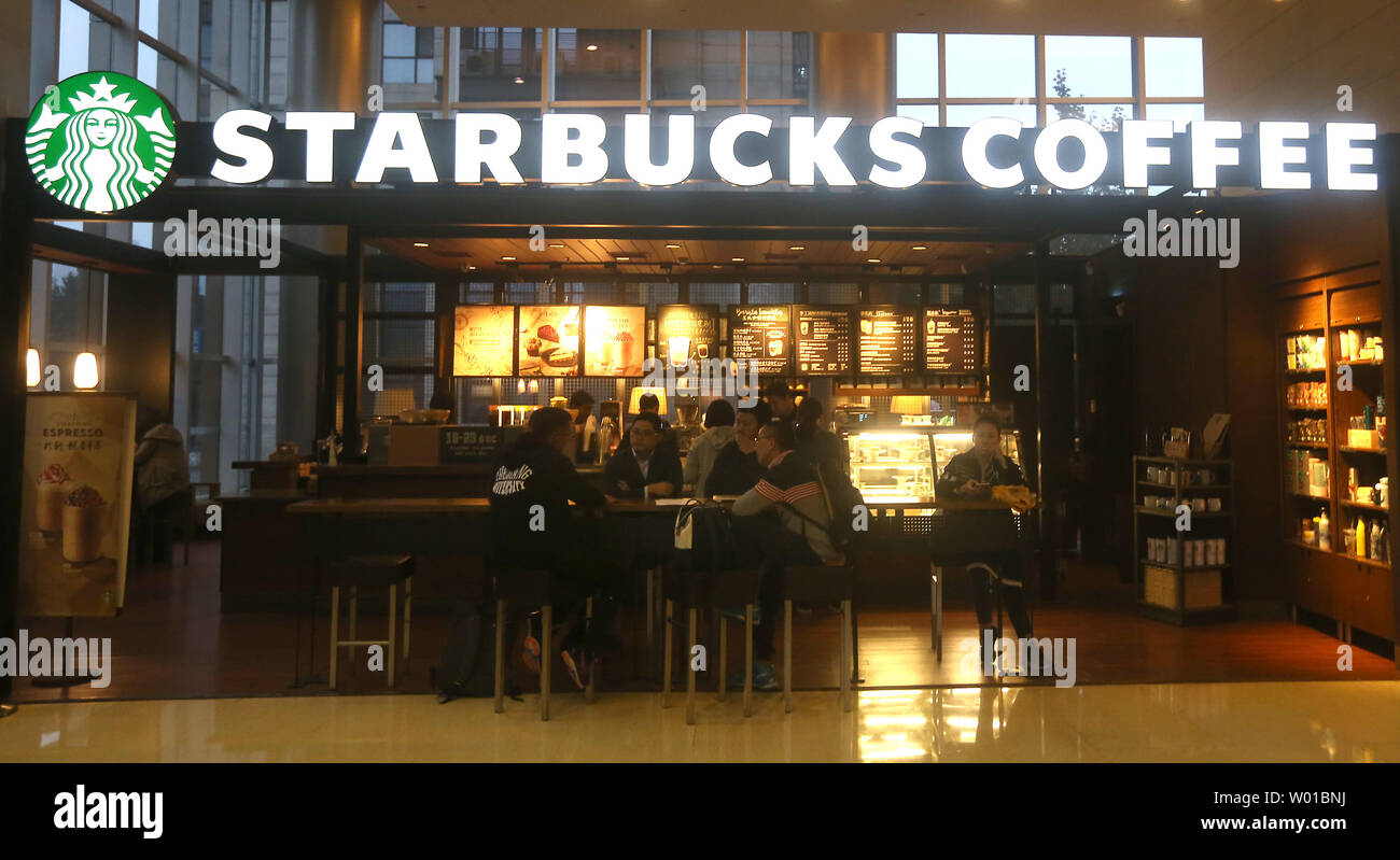 Chinese drink coffee at a Starbucks in central Beijing on October 24 ...