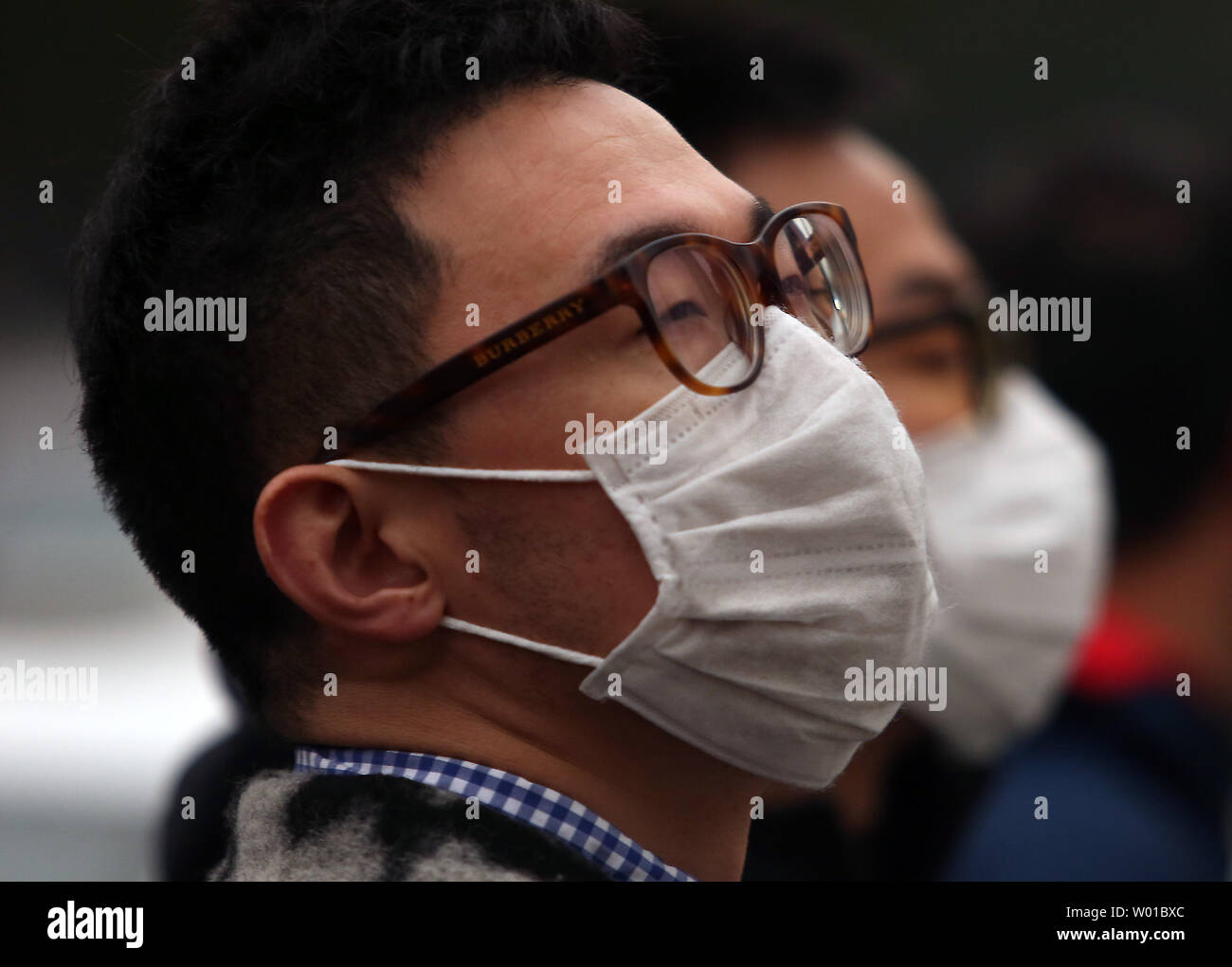 Chinese wear face masks to protect against the heavy smog hanging over ...