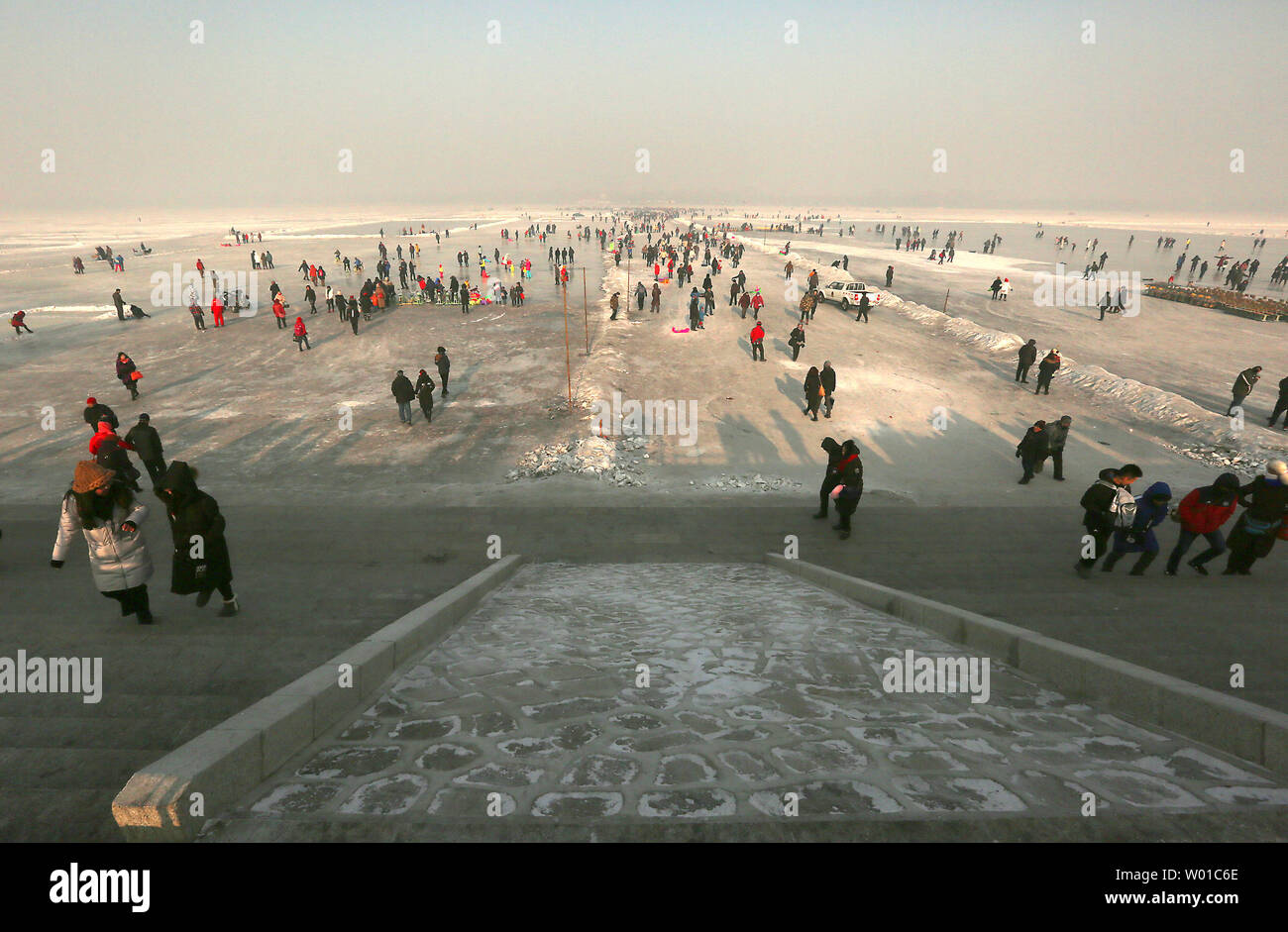 Chinese and foreign tourists visit the frozen Songhua River, in Harbin ...