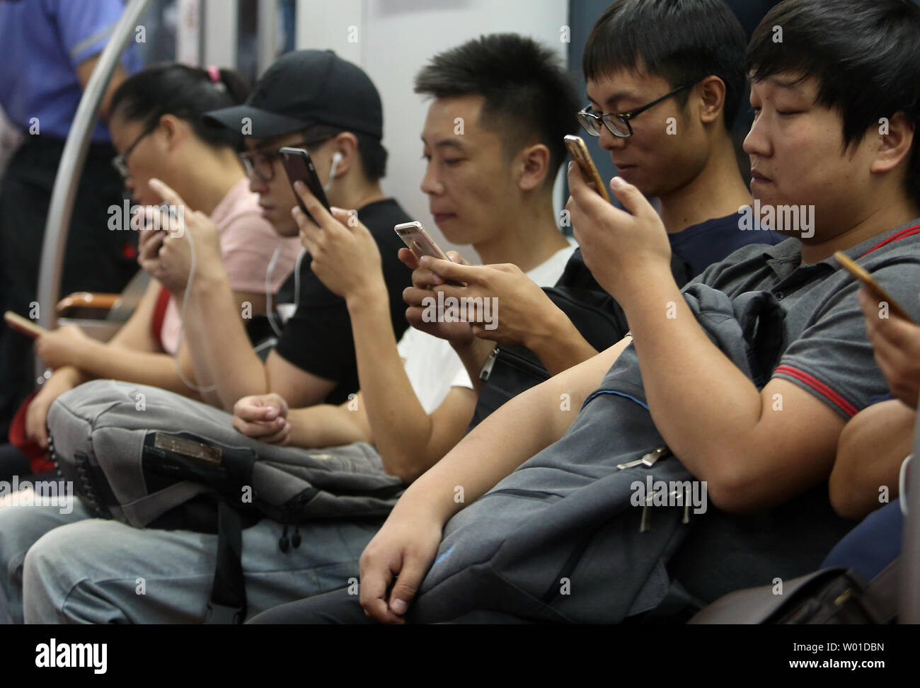 Chinese students use their smartphones while commuting to school on a ...
