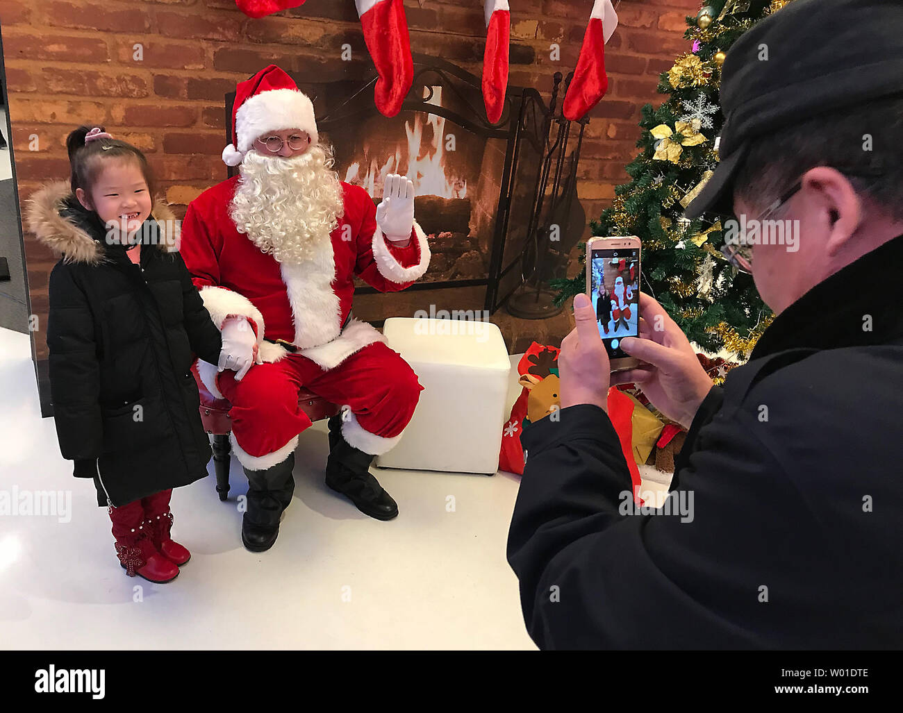 Chinese pose for a photo with Santa Claus in an international mall in ...