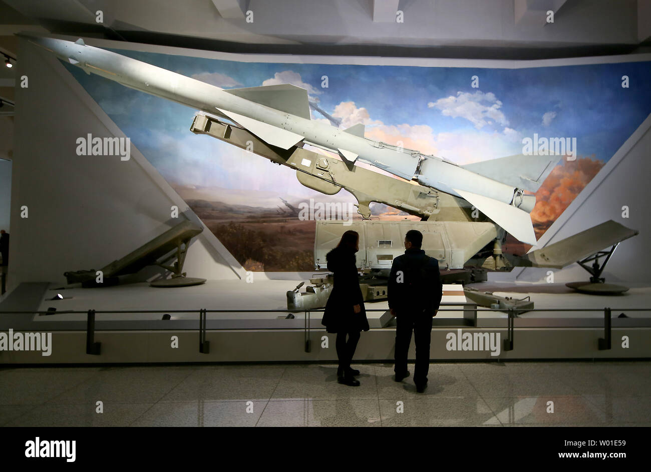Chinese visitors look at a ground-to-air missile on display at the ...