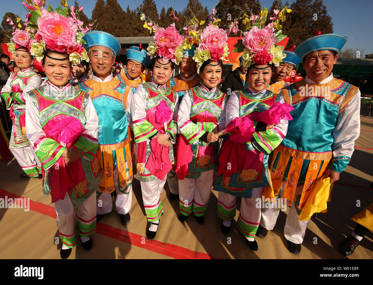 Chinese dancers wait to perform on an outdoor stage for a large crowd ...