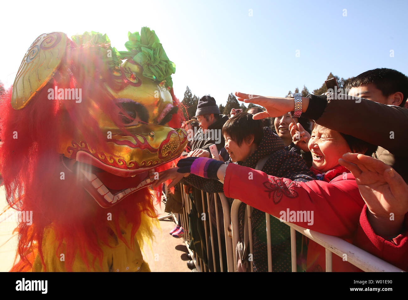 Chinese lion dancers greet a large crowd at a temple park's Spring ...