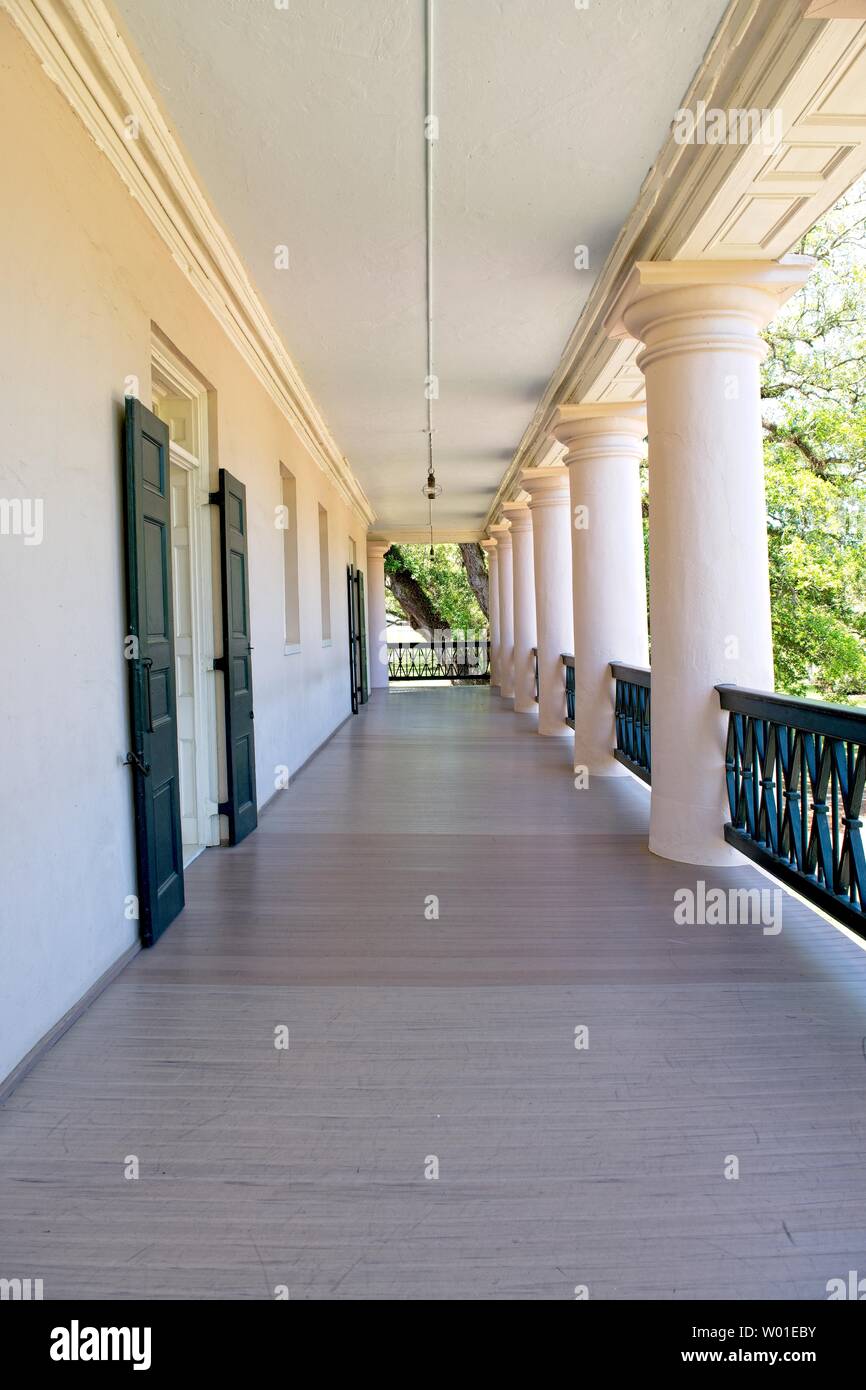 A view down an exterior hallway of a greek revival buildings with ...