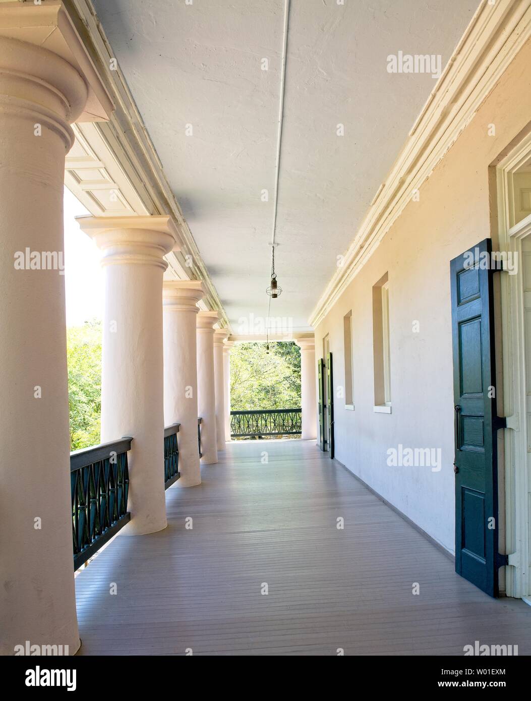 A view down an exterior hallway of a greek revival buildings with ...