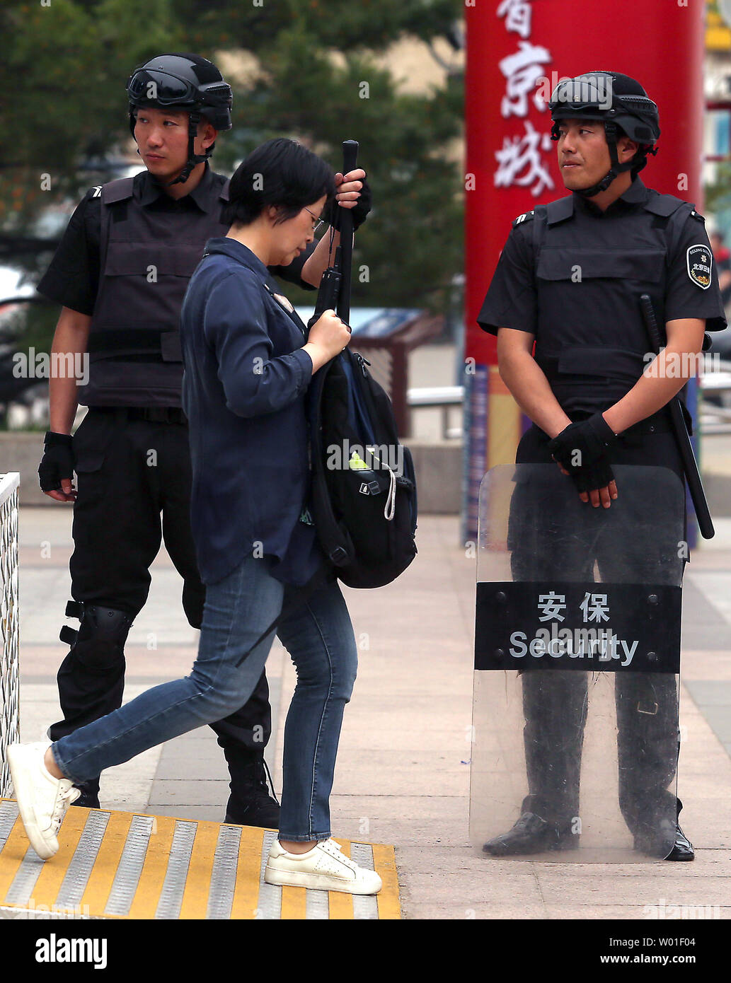 Chinese security guards stand near the entrance of a shopping mall as ...