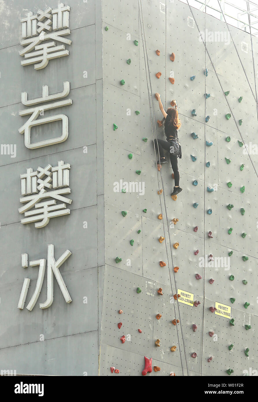 A Chinese woman approaches the top of a 40m outdoor climbing wall in ...
