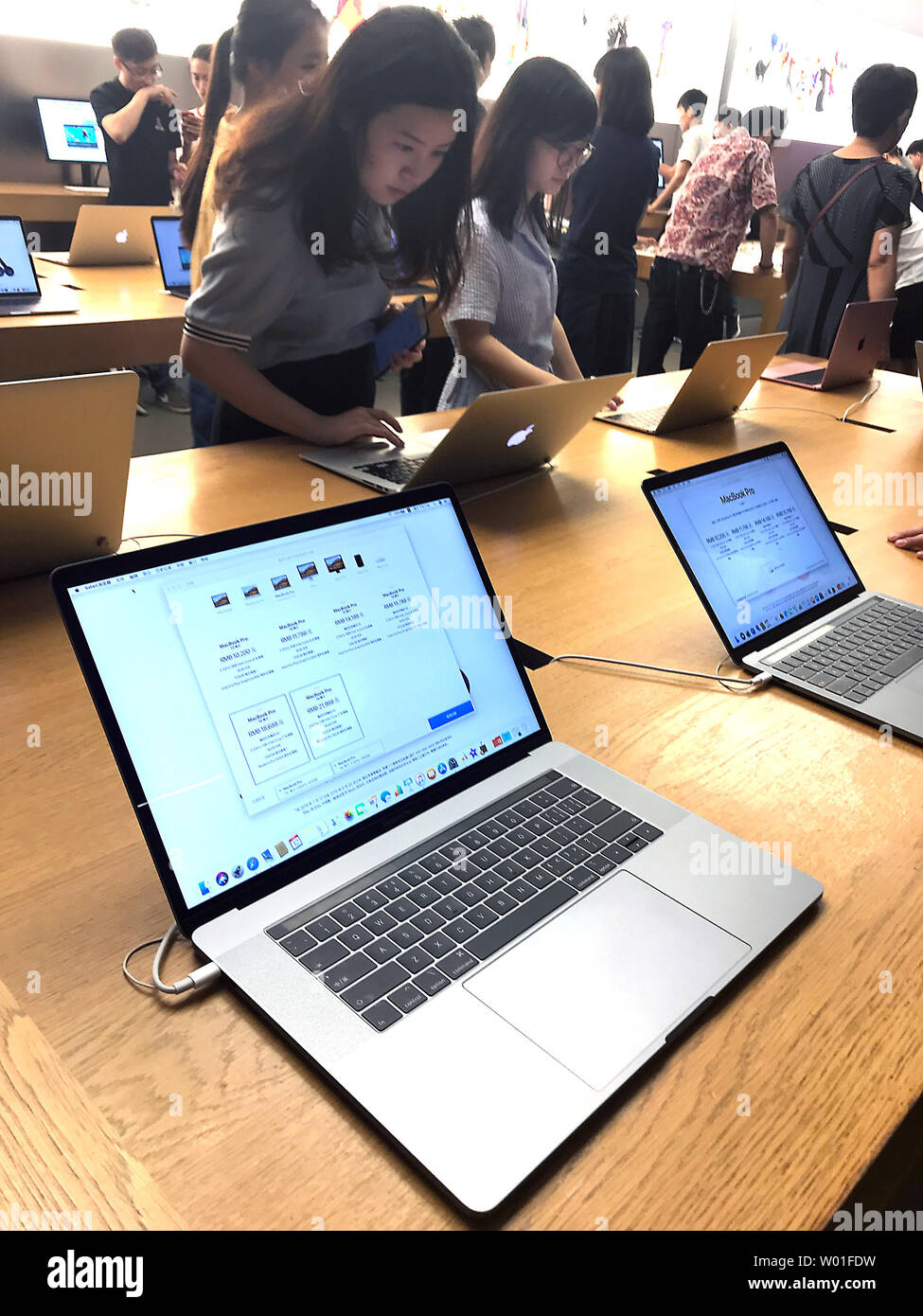 Chinese check out the latest computers and iPhones at an Apple store in ...