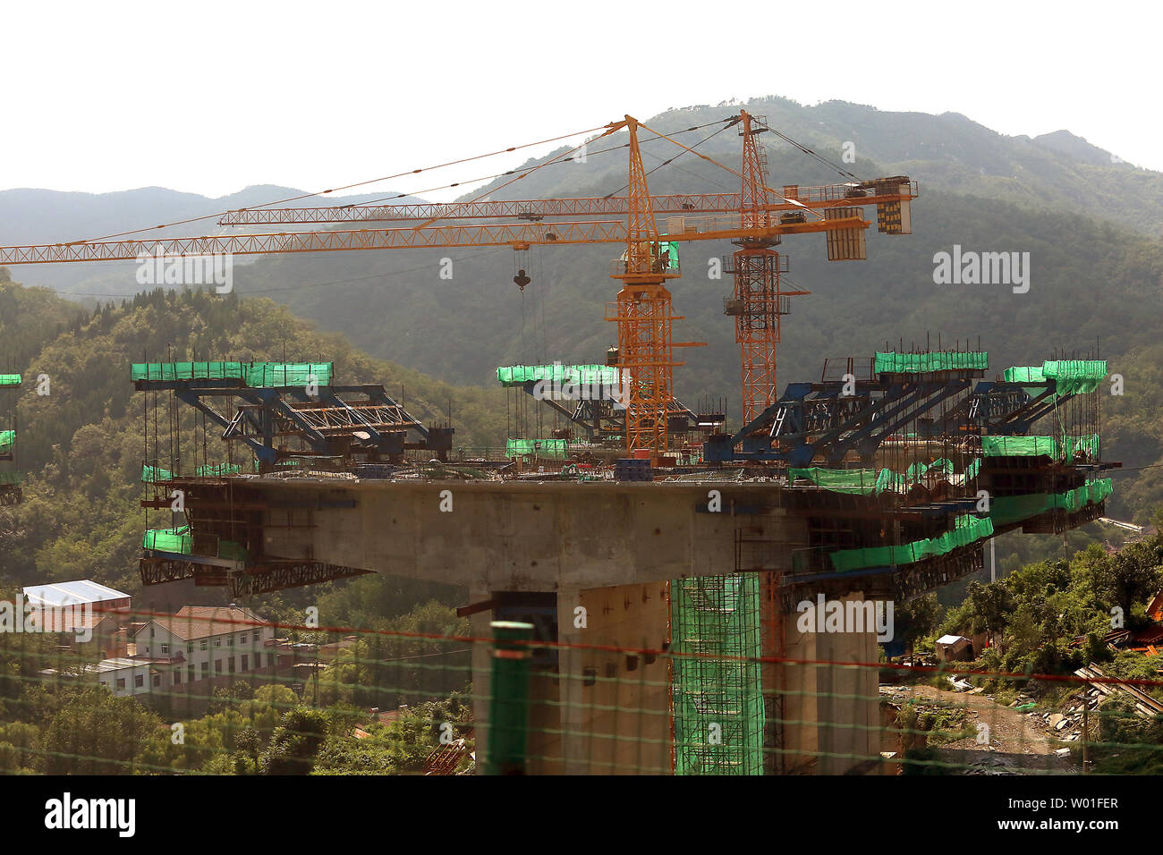 Construction workers build a massive bridge outside of Zibo, Shandong ...