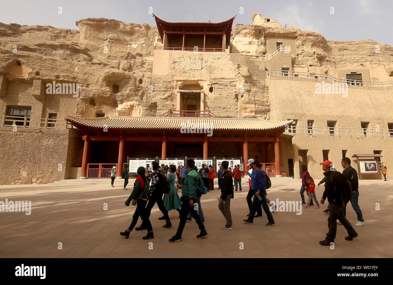 Tourists visit the Magao Caves, also known as the Thousand Buddha ...