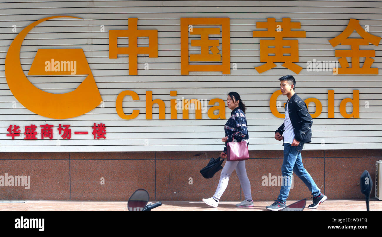 Chinese walk past a China Gold jewelry store in Dunhuang, Gansu ...