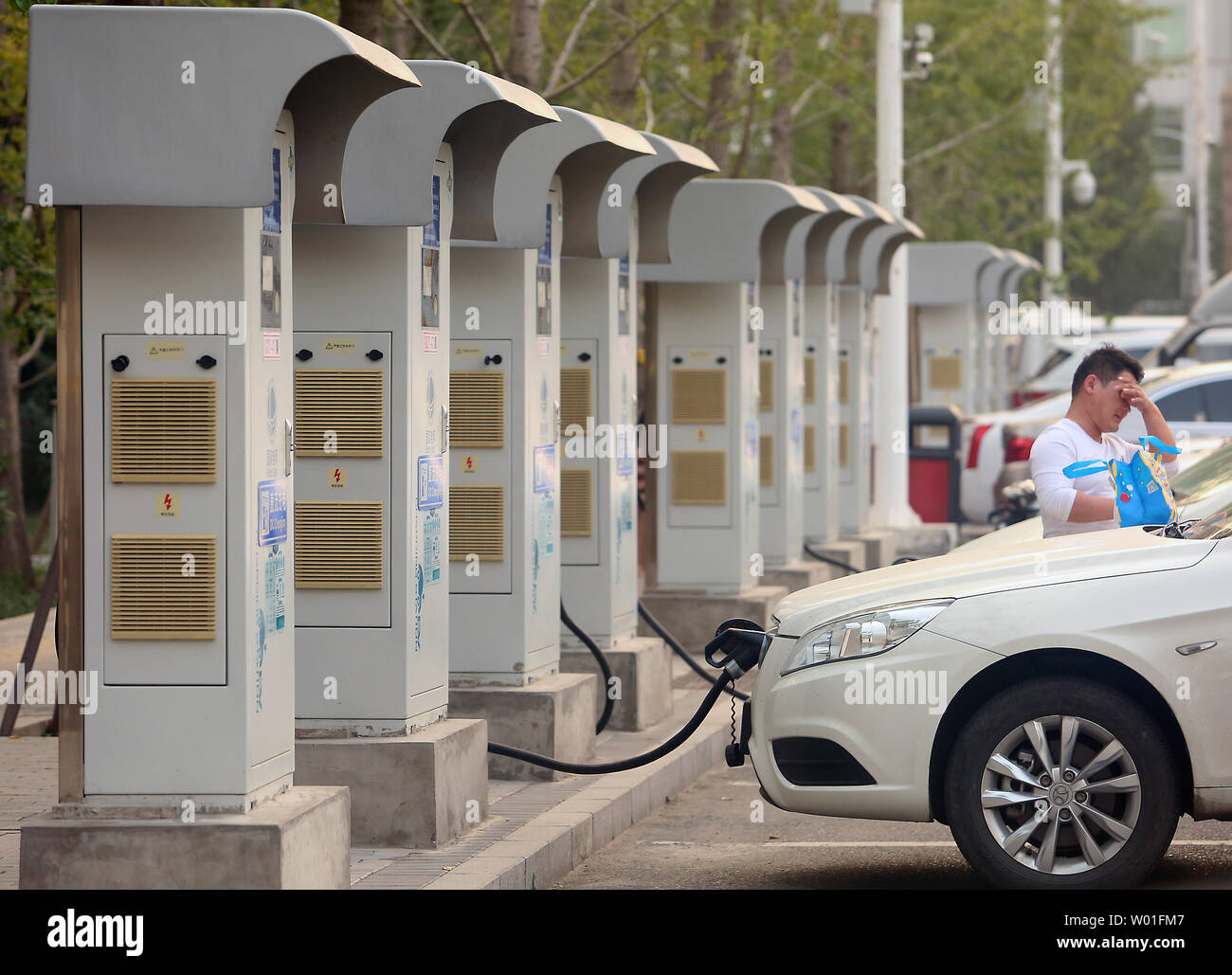 A Chinese man waits for his Chinese electronic vehicle (EV) to be ...