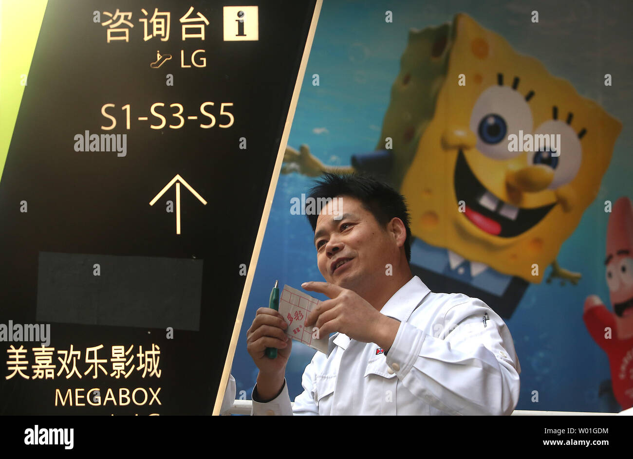 A Chinese man walks by a soon-to-open clothing store featuring designs ...