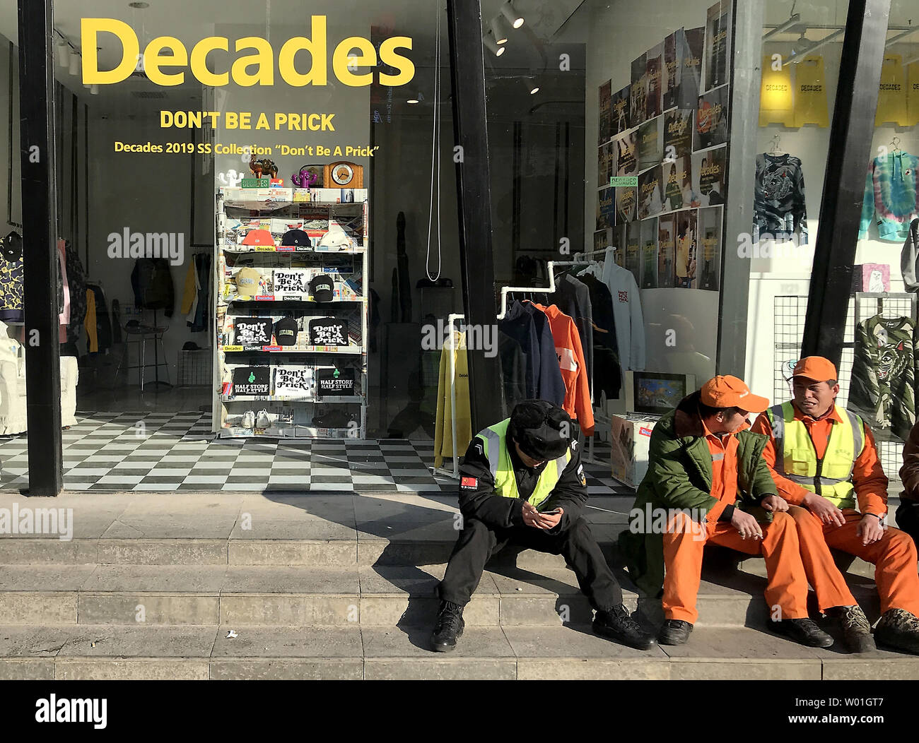 Chinese security and maintenance workers sit in front of a new, novelty ...