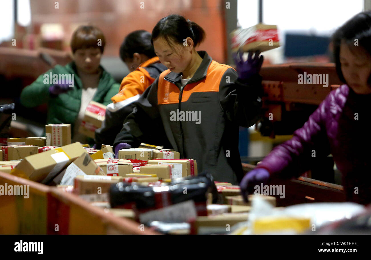 Workers sort through packages at STO Express's logistics center in Yiwu ...