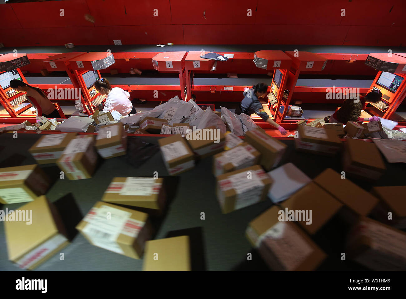 Workers sort through packages at STO Express's logistics center in Yiwu ...