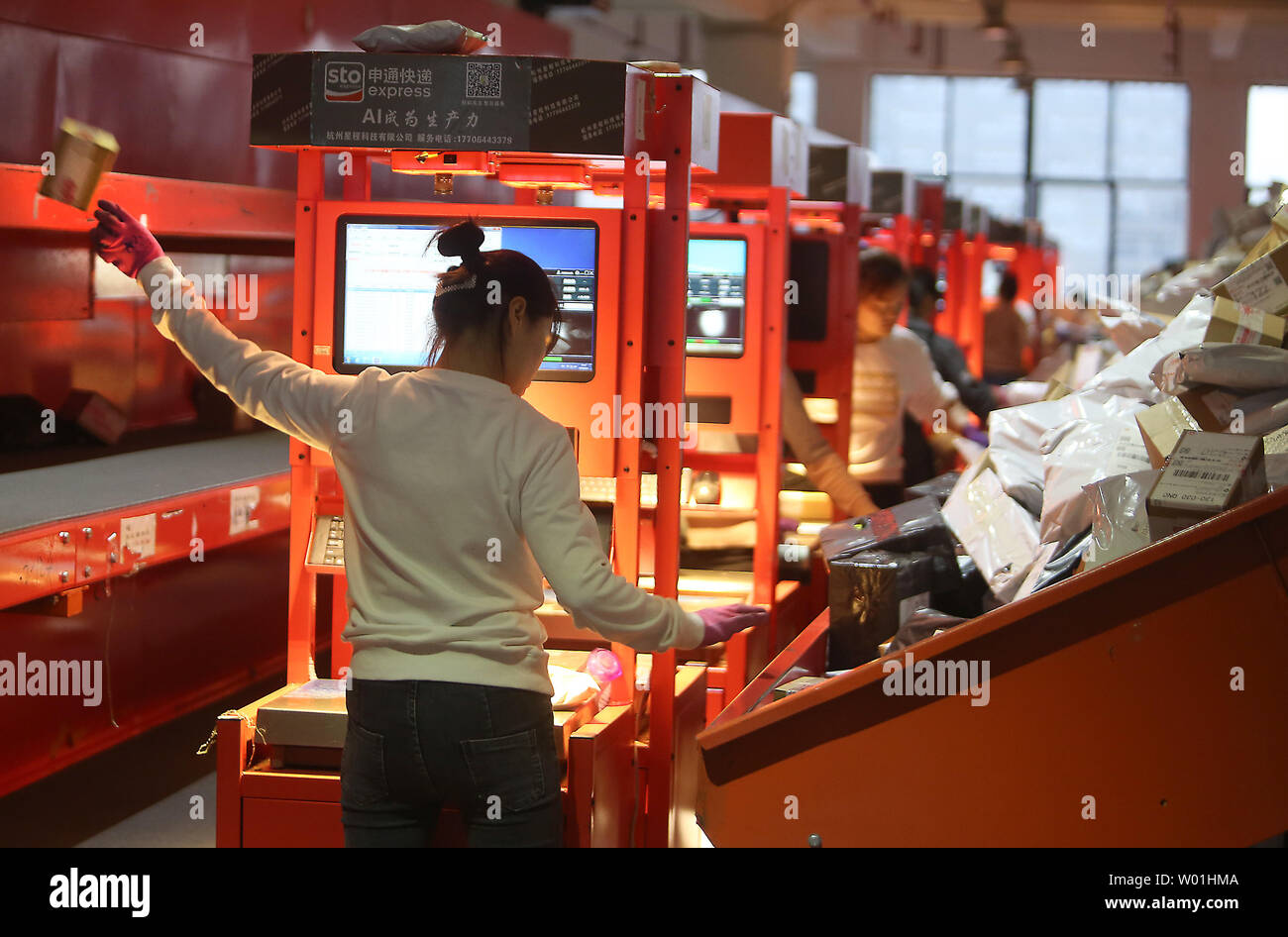 Workers sort through packages at STO Express's logistics center in Yiwu ...