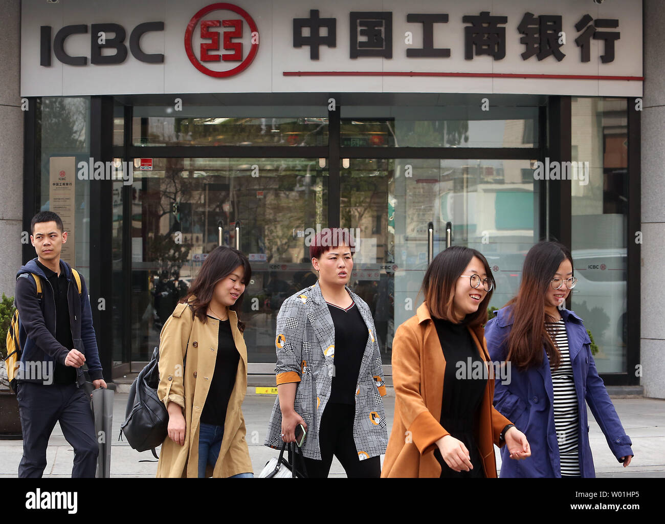 Chinese walk past an Industrial and Commercial Bank of China (ICBC ...