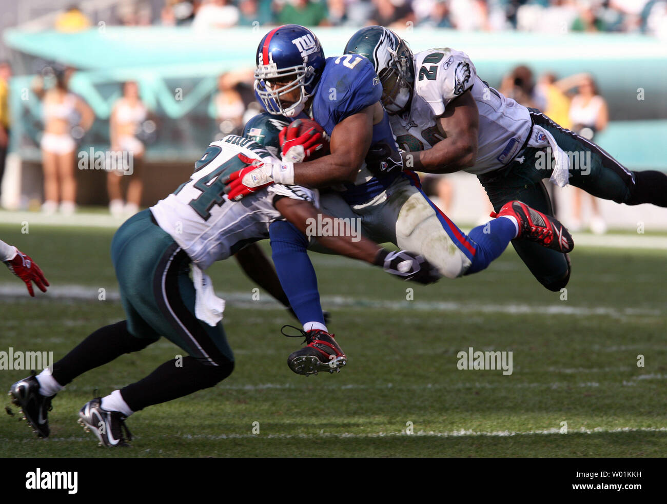 New York's running back Tiki Barber (#21) is airborne as he is hit from ...