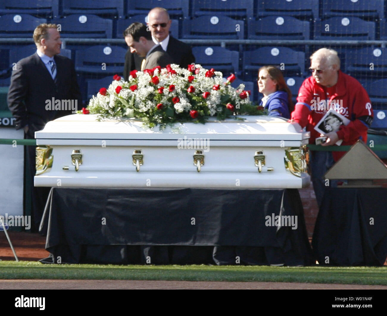 A Philadelphia Phillies fan reaches over to touch the coffin of Hall of ...