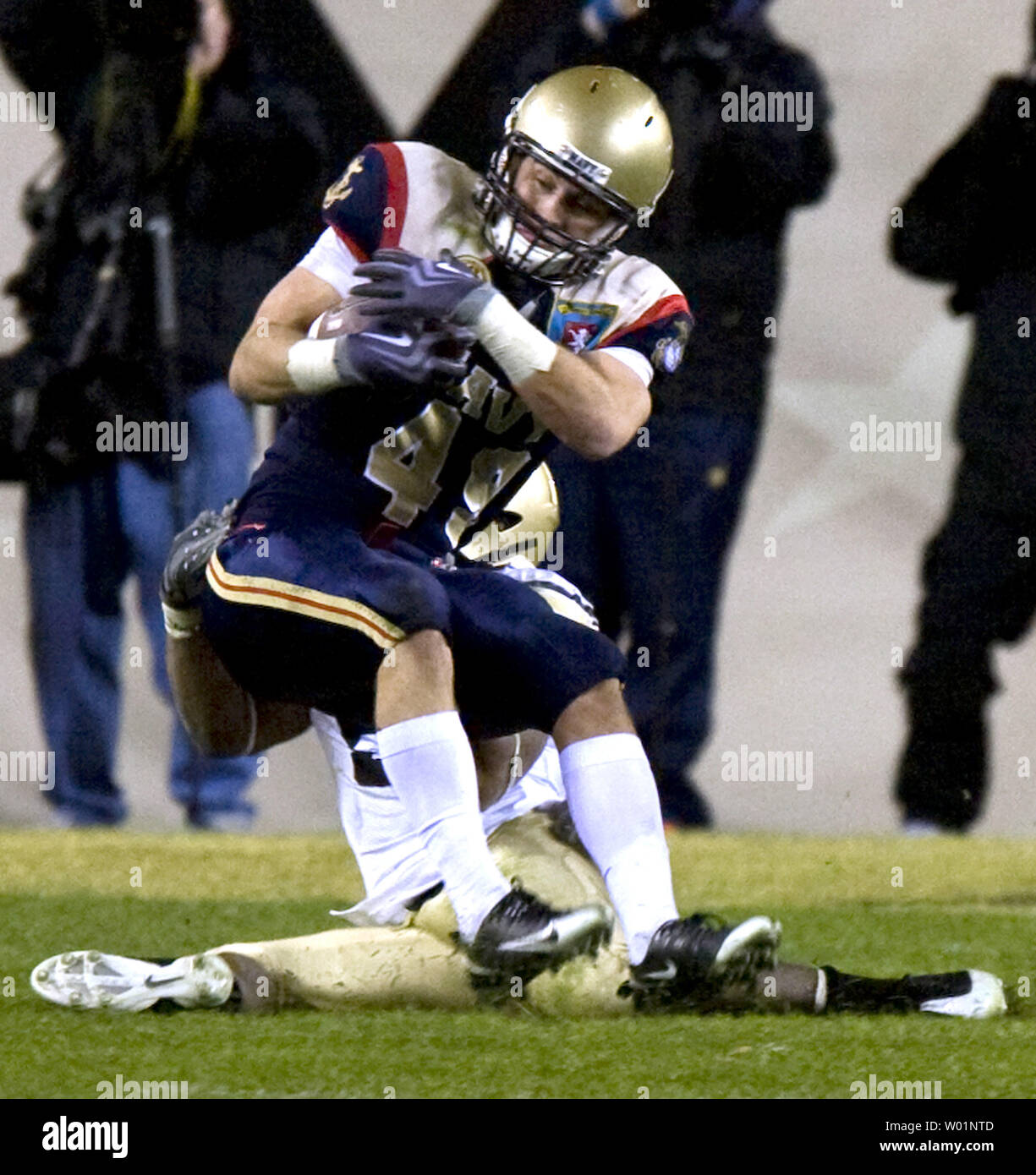 Navy's Craig Schaefer is pulled down by Army's Patrick Mealy after a ...