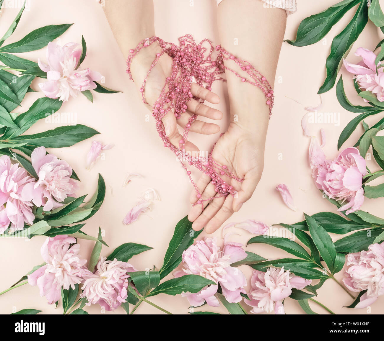 two hands of a young girl with smooth skin and a bouquet of pink ...